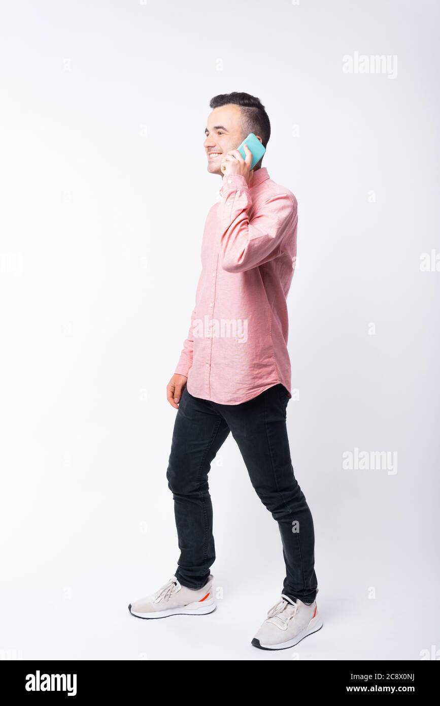 Full body lenght photo of a young man talking on the phone over white ...