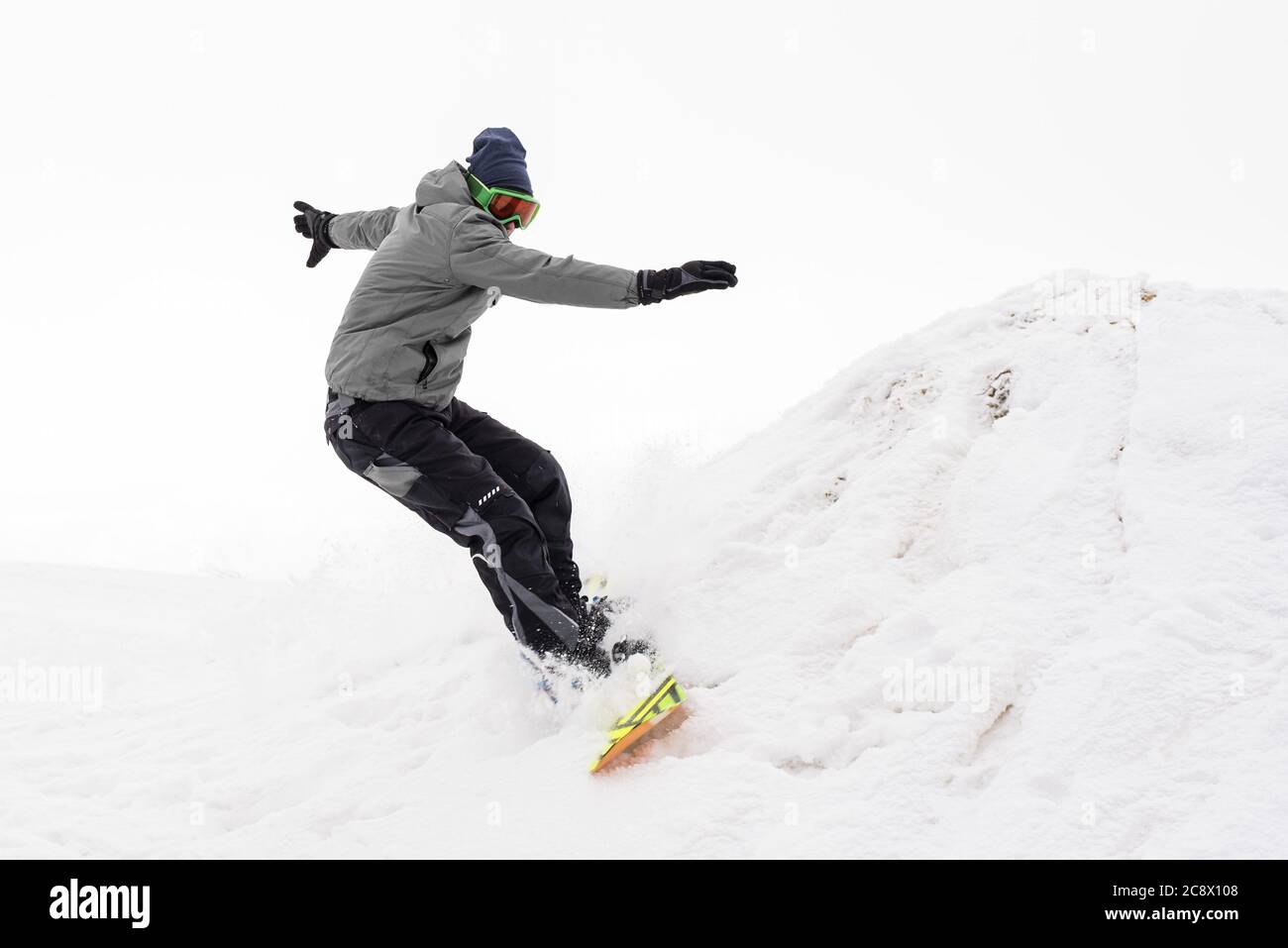 Cool young male snowboarder doing stunts on a slope Stock Photo - Alamy