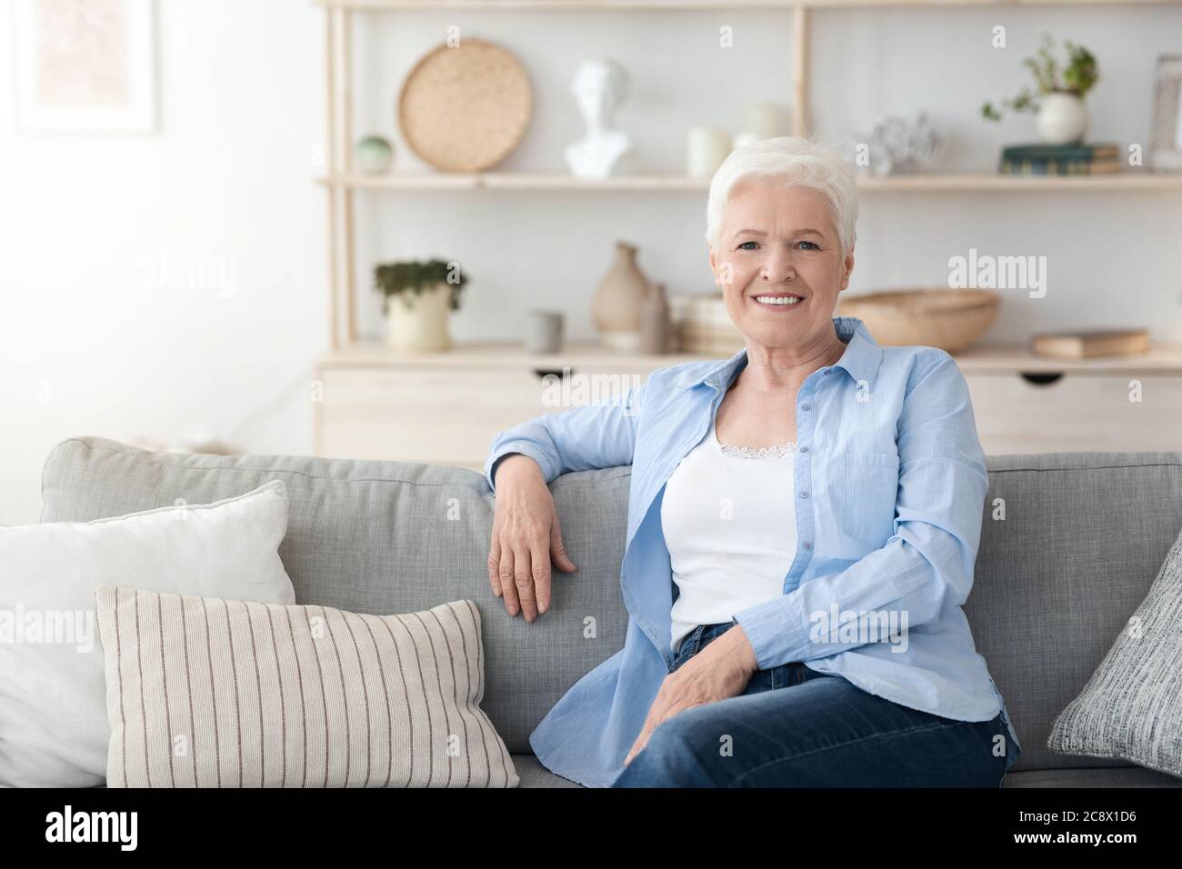 Relaxed Elderly Woman Posing On Couch Im Cozy Home Interior Stock Photo ...