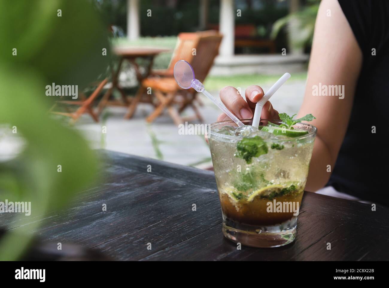 Woman's hands holding straw with glass of fresh mojito cocktail Stock ...