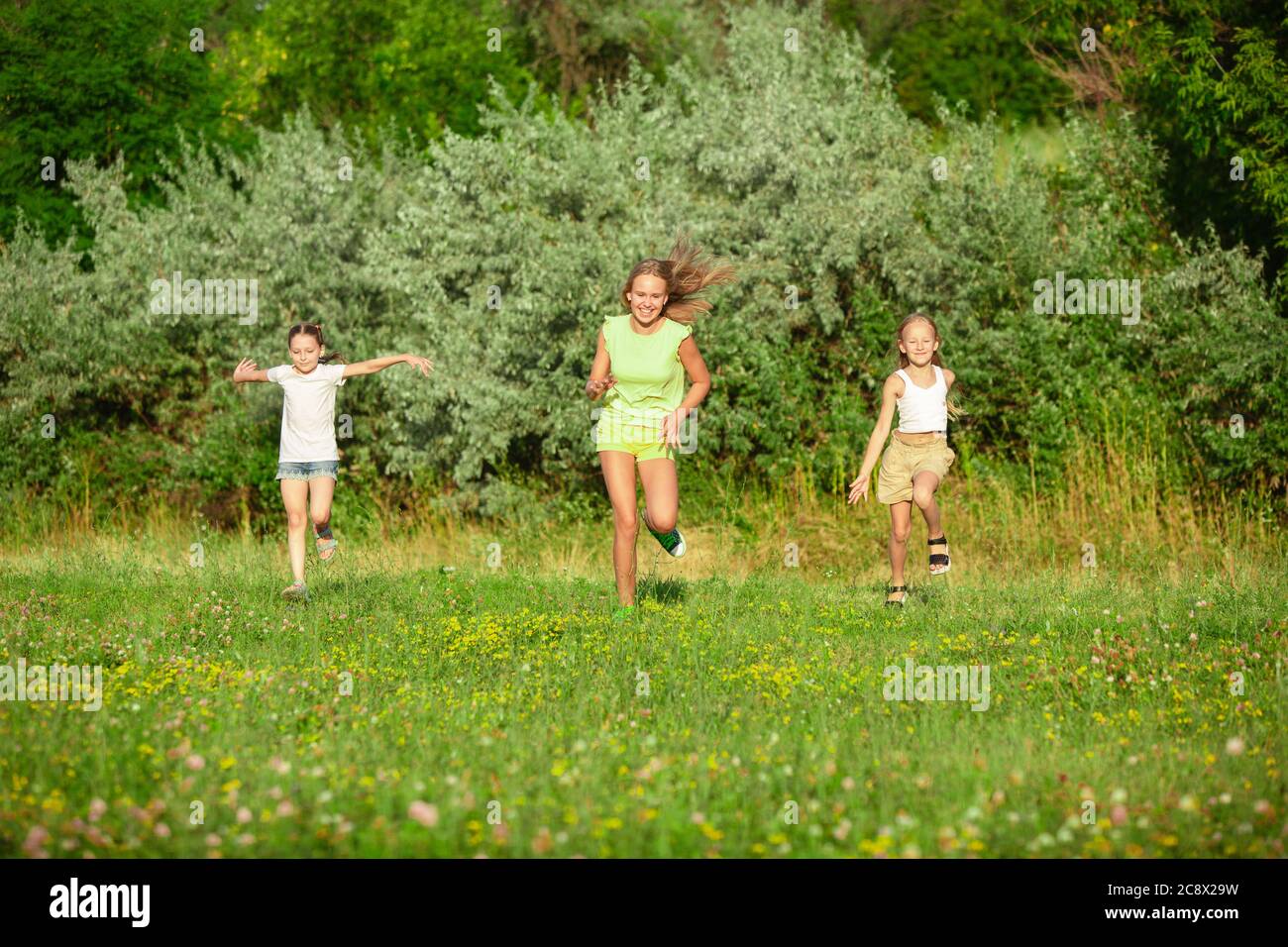 Kids, children running on meadow in summer's sunlight. Look happy ...