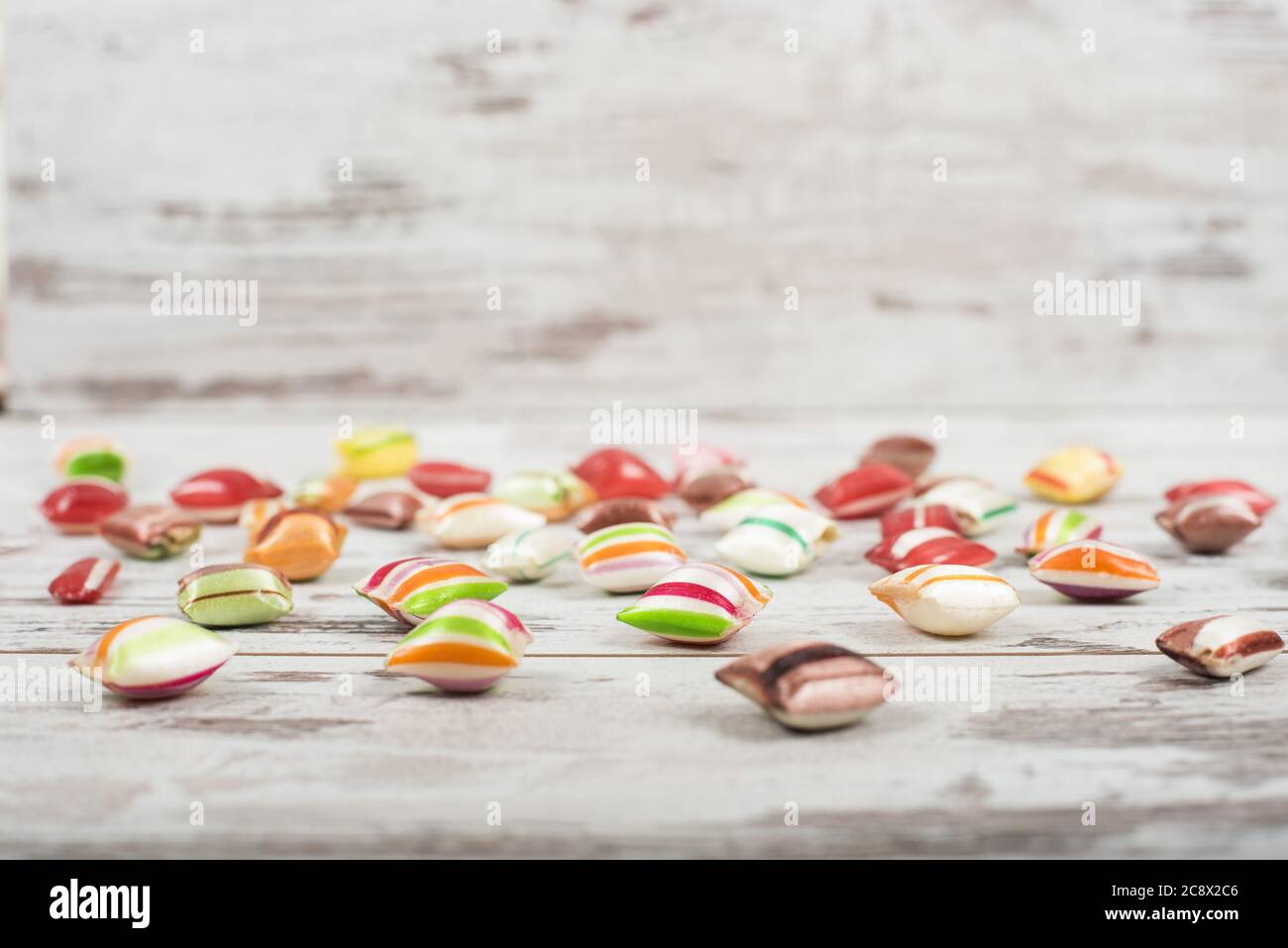 Closeup shot of striped sweet candies on a white table Stock Photo - Alamy