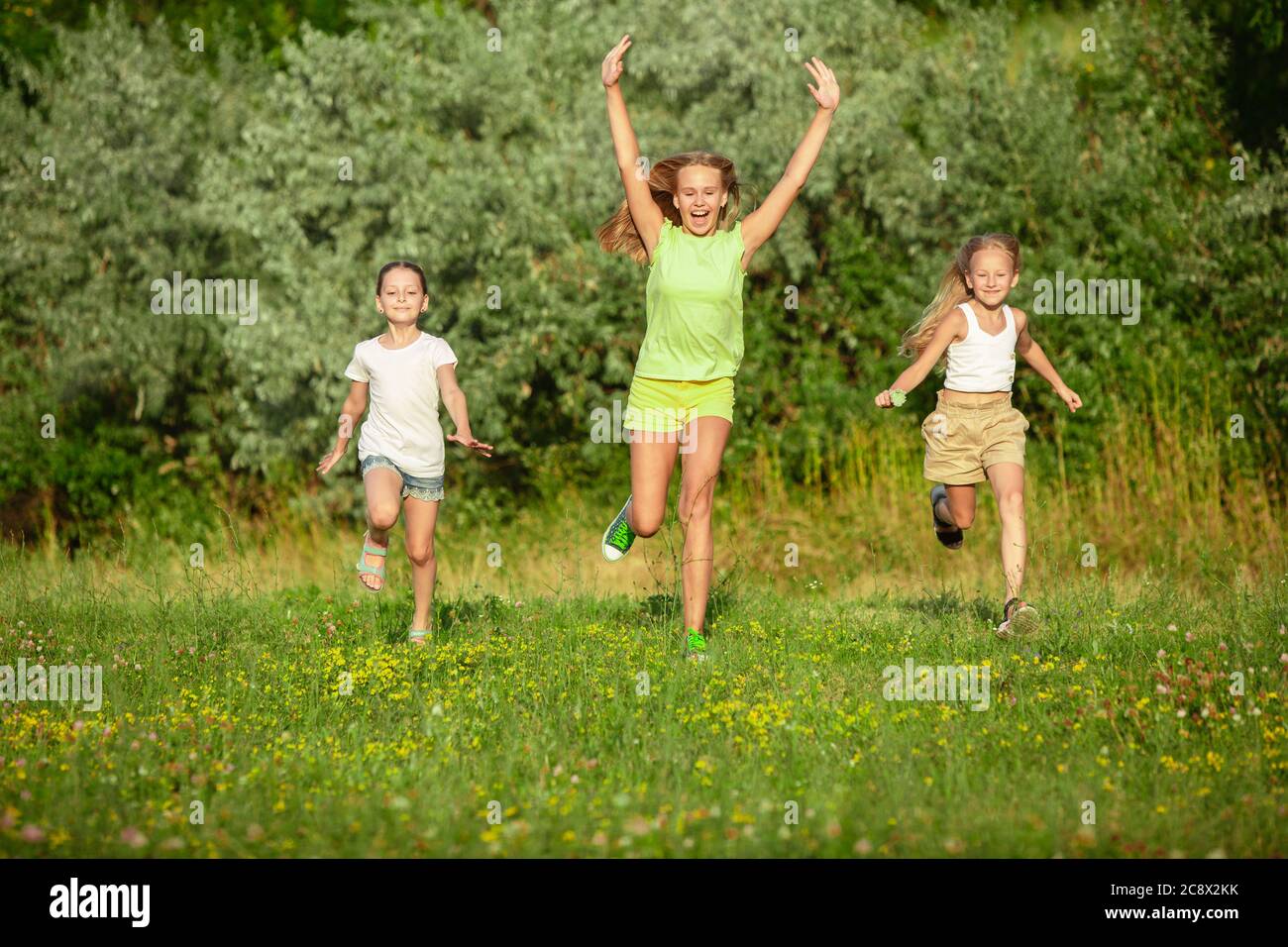 Kids, children running on meadow in summer's sunlight. Look happy ...