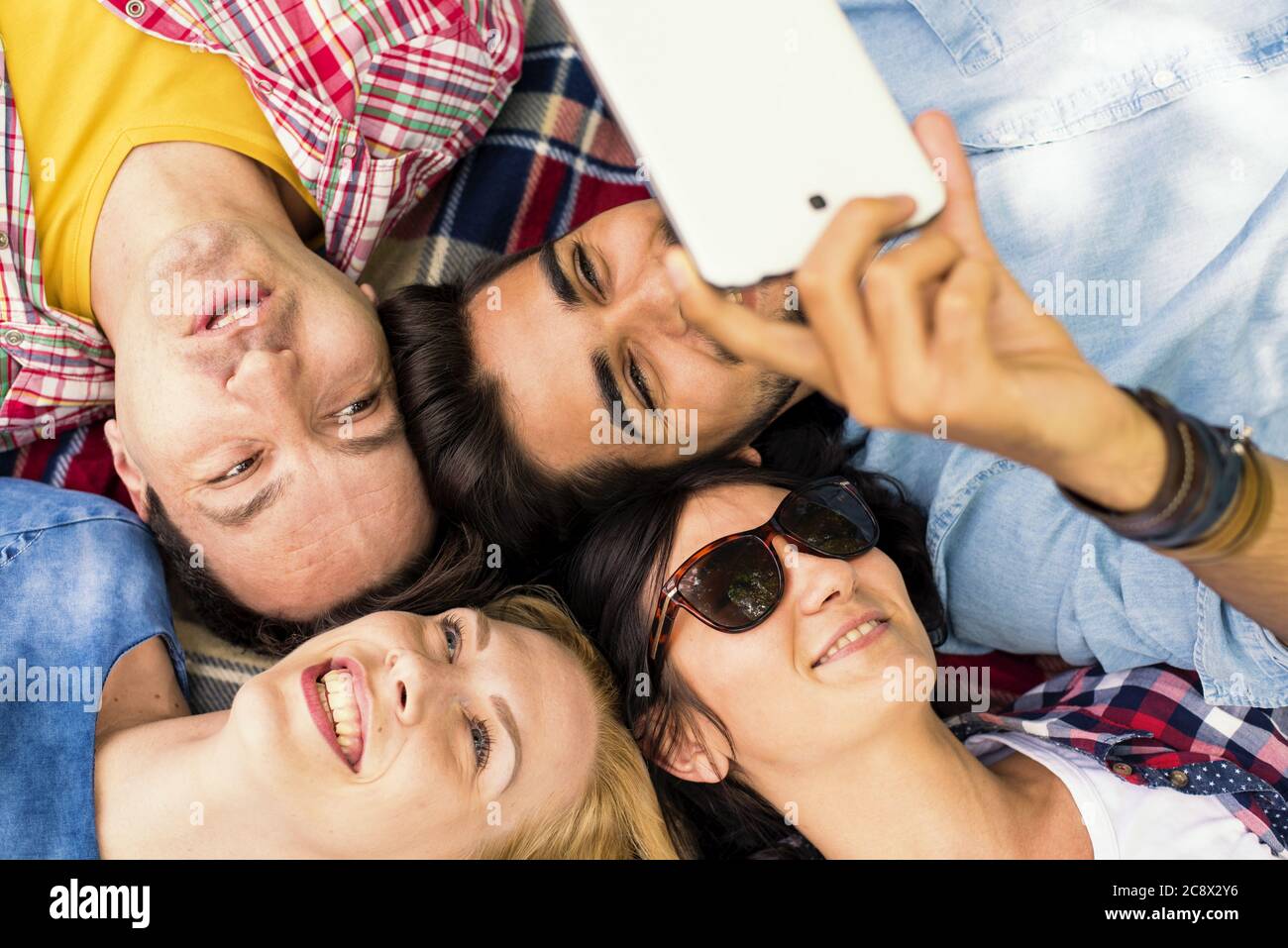Closeup shot of four friends laying down and taking a selfie Stock ...