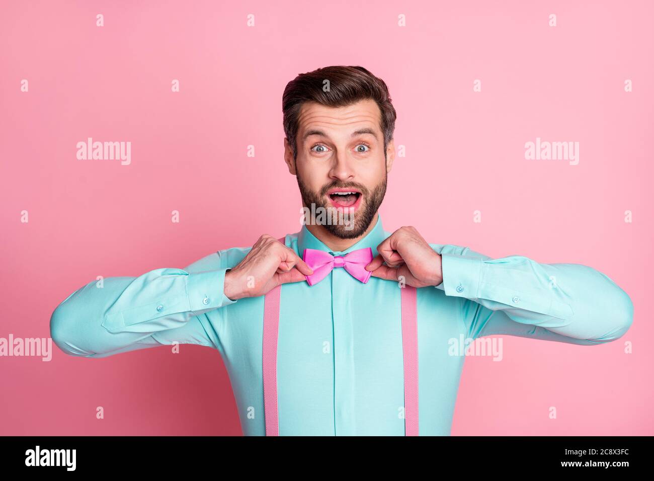 Portrait of astonished crazy funny funky man look mirror fix his bow ...