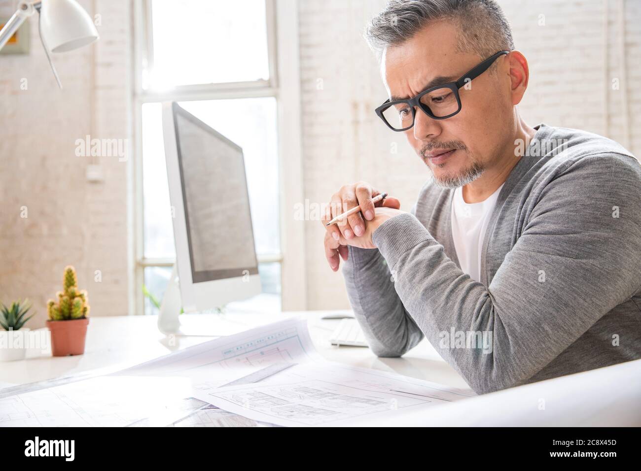 Indoor think drawings, a senior designer Stock Photo - Alamy