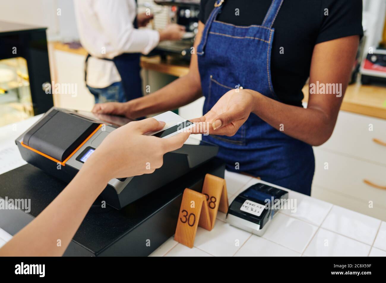 Hands of customer giving credit card to cashier when paying for order ...