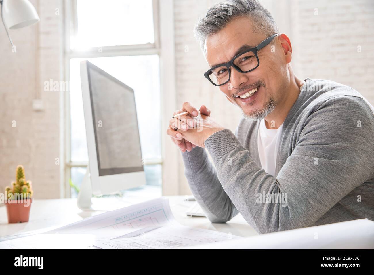 The indoor office senior designer portrait Stock Photo - Alamy
