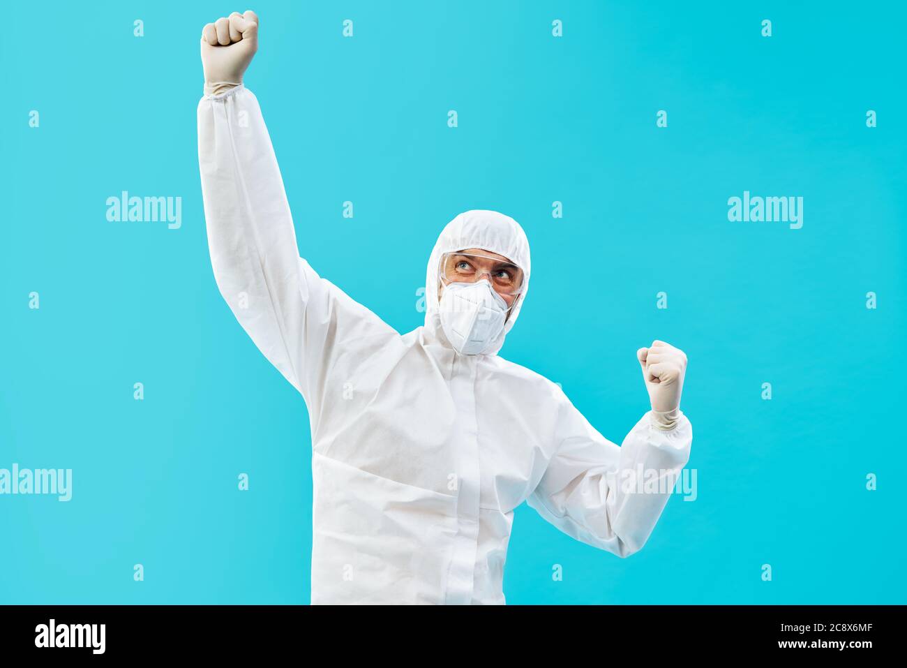 Happy doctor in PPE suit celebrating his success with winner gesture ...