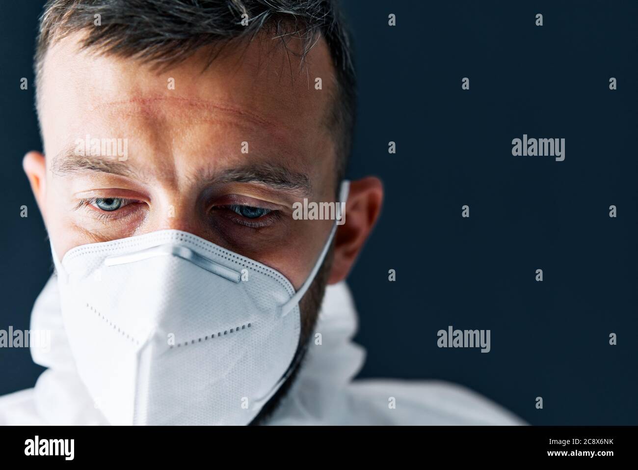 Exhausted doctor in PPE suit uniform in stress on black background ...