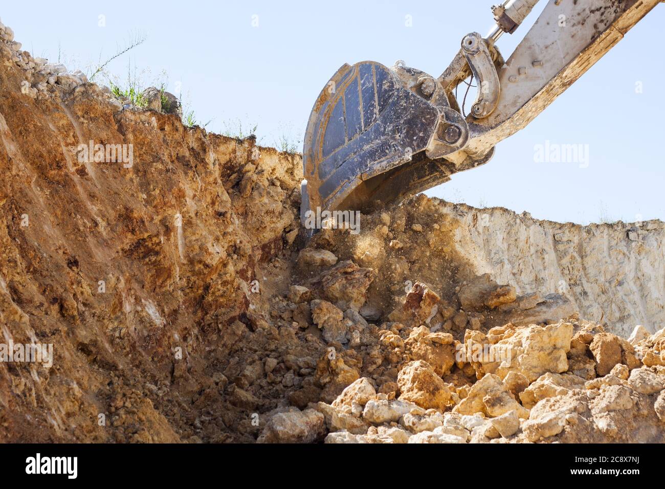 Large rusty excavator breaking down land at a construction site Stock ...