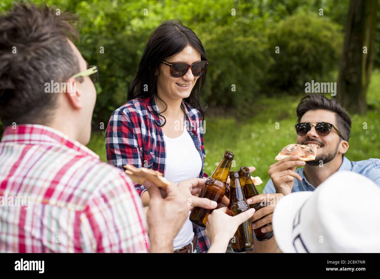 Cheerful group of caucasian friends drinking beer and eating pizza on a ...