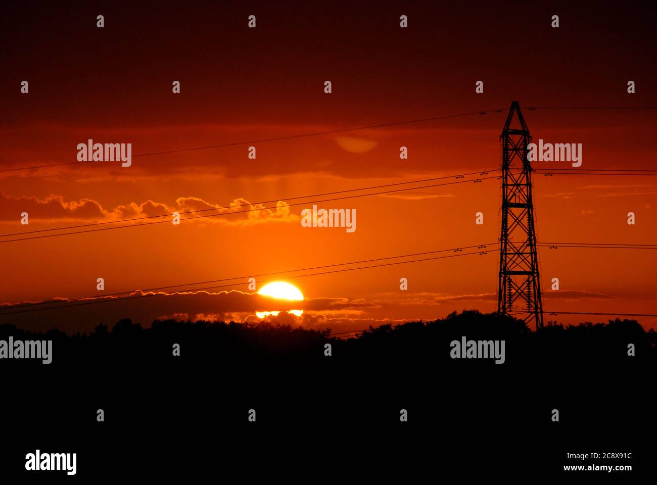 Contrast of power sources, from setting sun seen behind suspended ...
