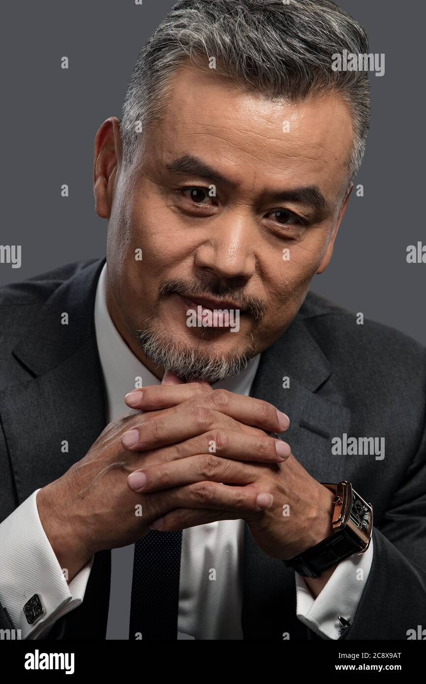 Successful business tycoon, his hands crossed Stock Photo - Alamy