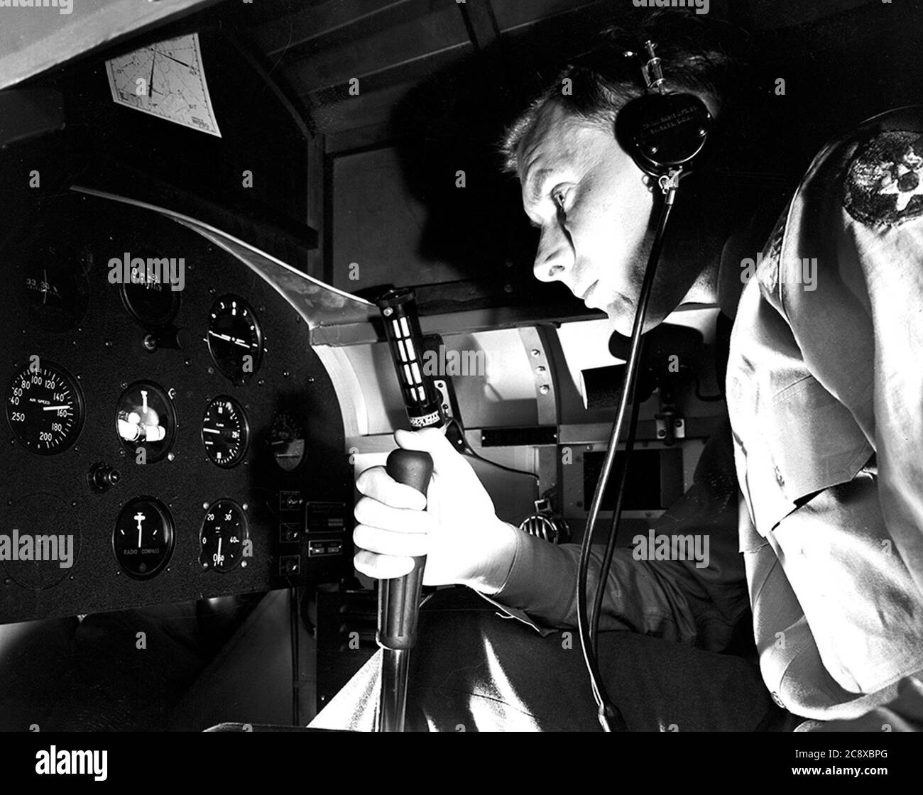 Military personnel using link trainer with kollsman instrument panel ...