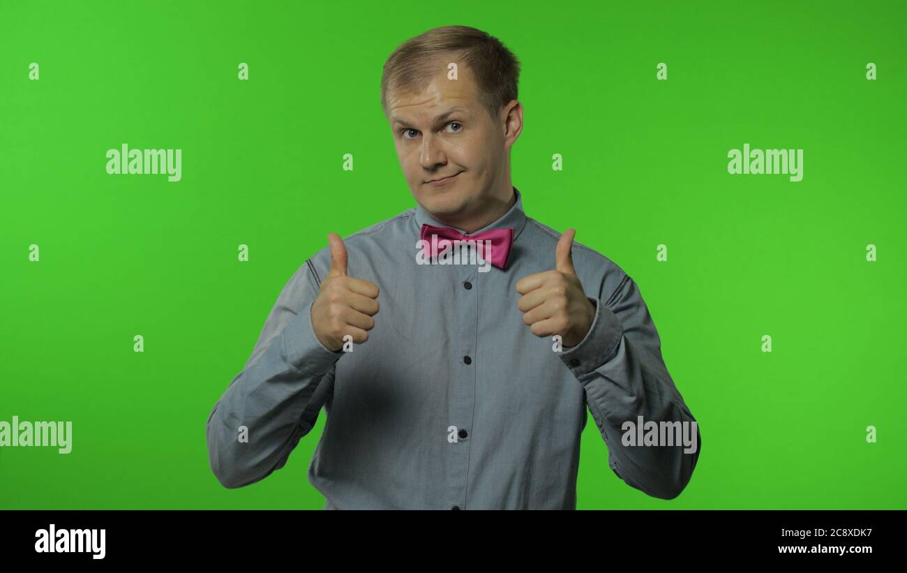 Cheerful glad man showing thumbs up and smiling at camera with ...