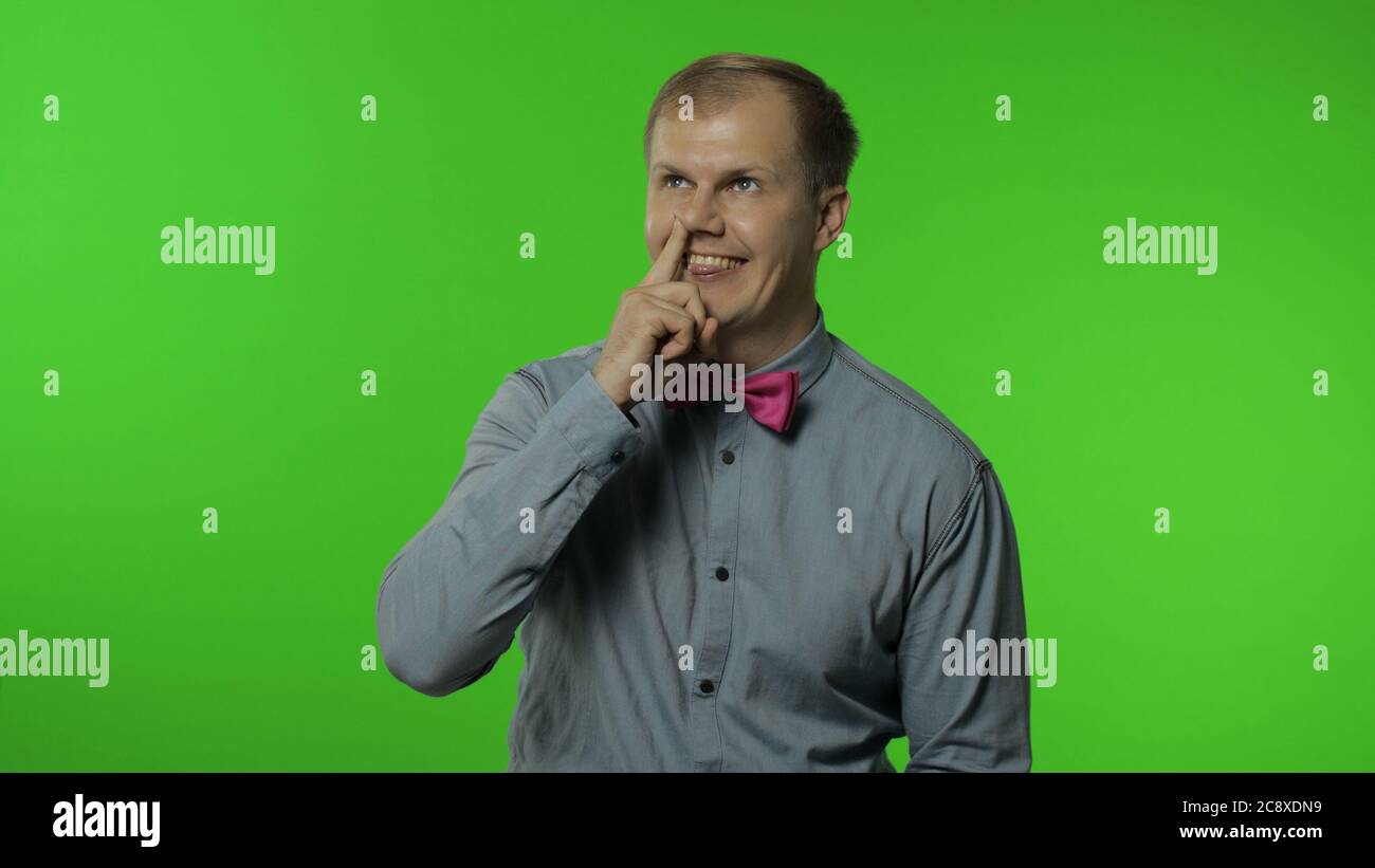 Funny stupid man picking nose with silly brainless humorous expression ...