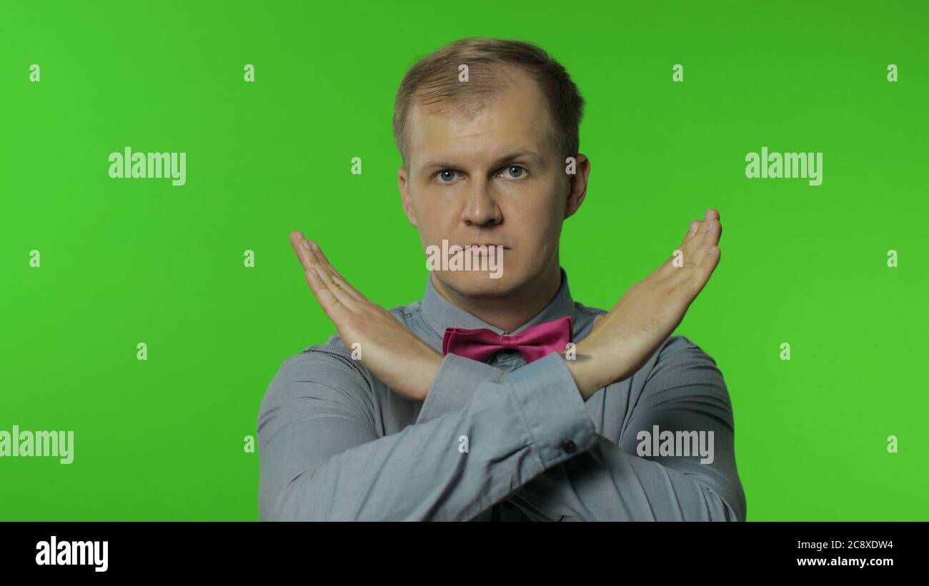 Displeased serious man crossed his arms in X sign and saying no ...