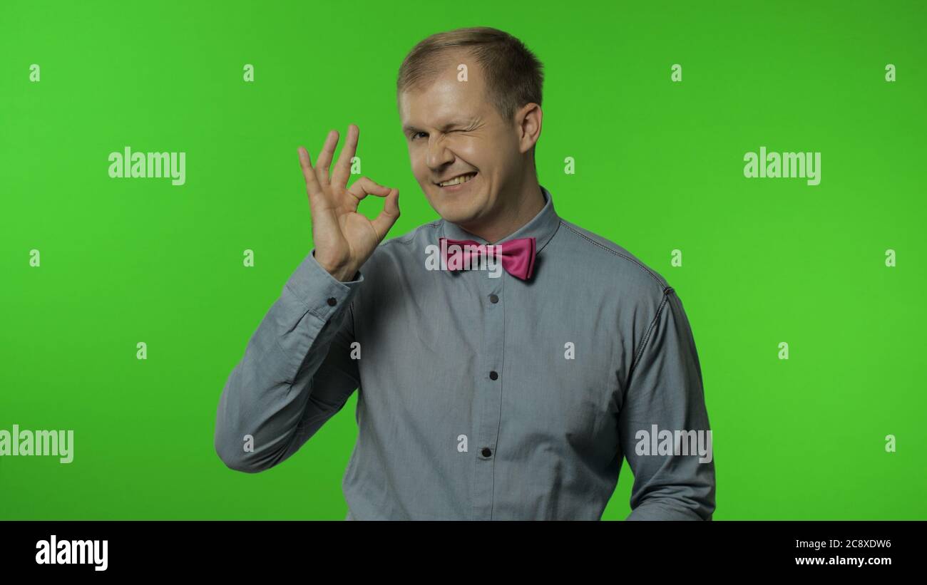 Cheerful glad man showing ok gesture and smiling at camera with ...