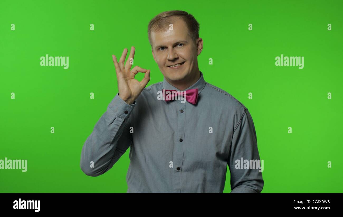 Cheerful glad man showing ok gesture and smiling at camera with ...