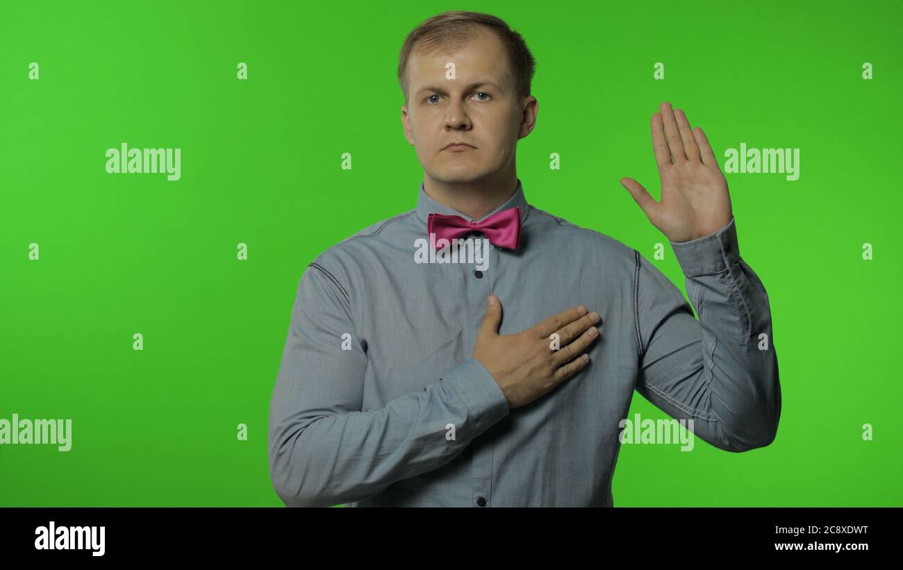 I swear. Worried honest man raising his hand up, touching chest and ...