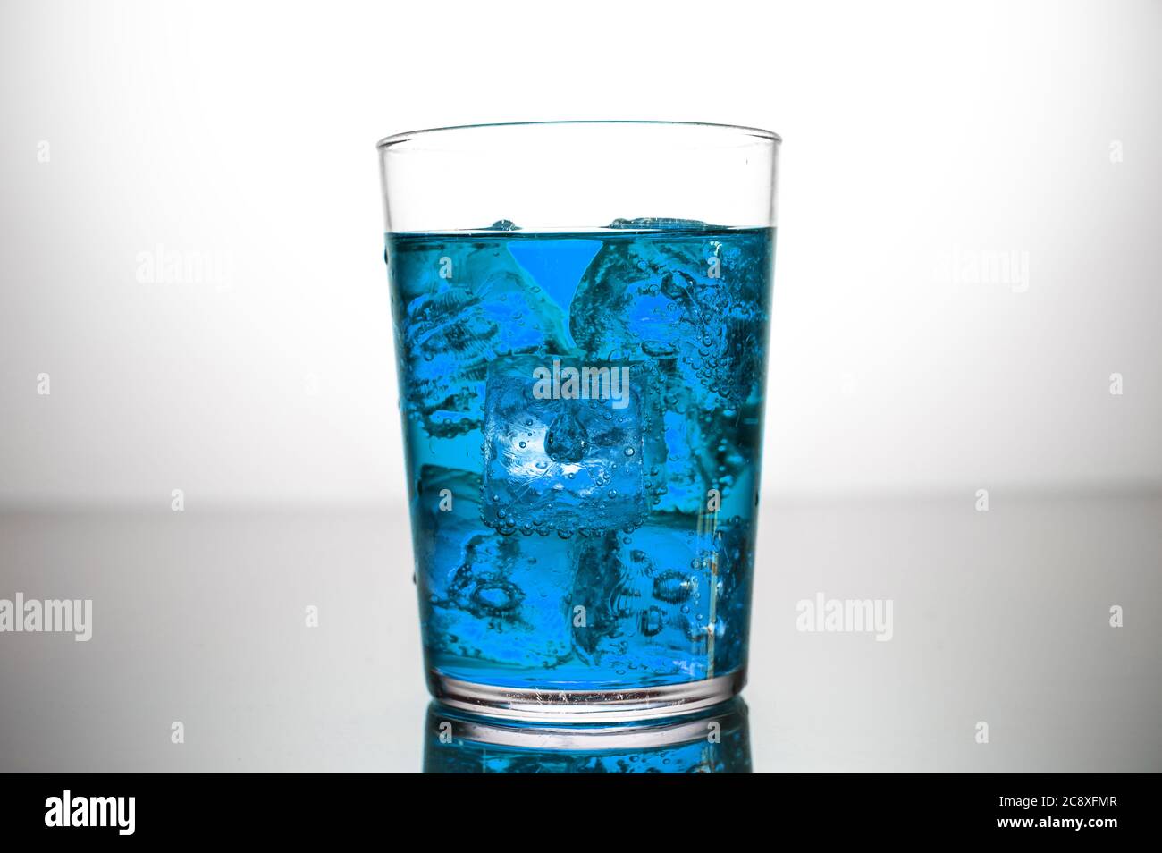 a glass of blue drink with ice cubes Stock Photo - Alamy