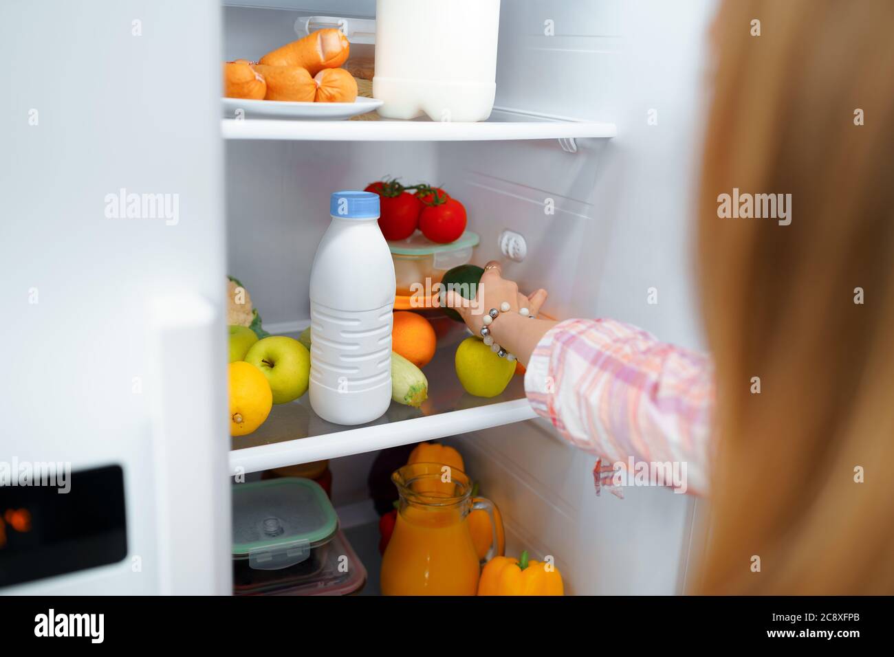 Hand of a woman taking food from the fridge Stock Photo - Alamy