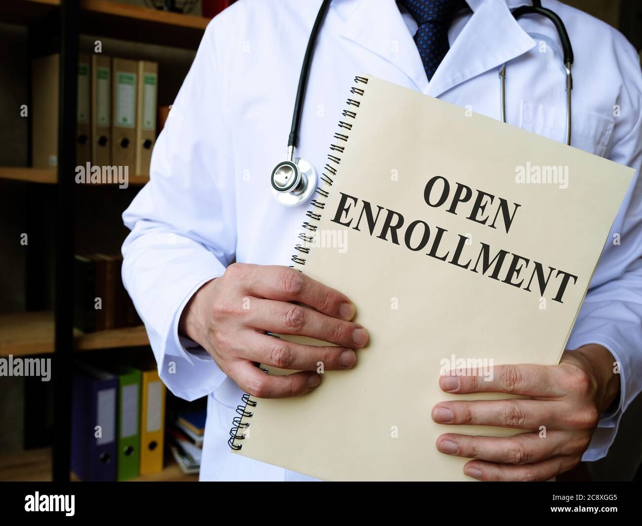 Doctor shows Annual open enrollment stack of papers Stock Photo - Alamy