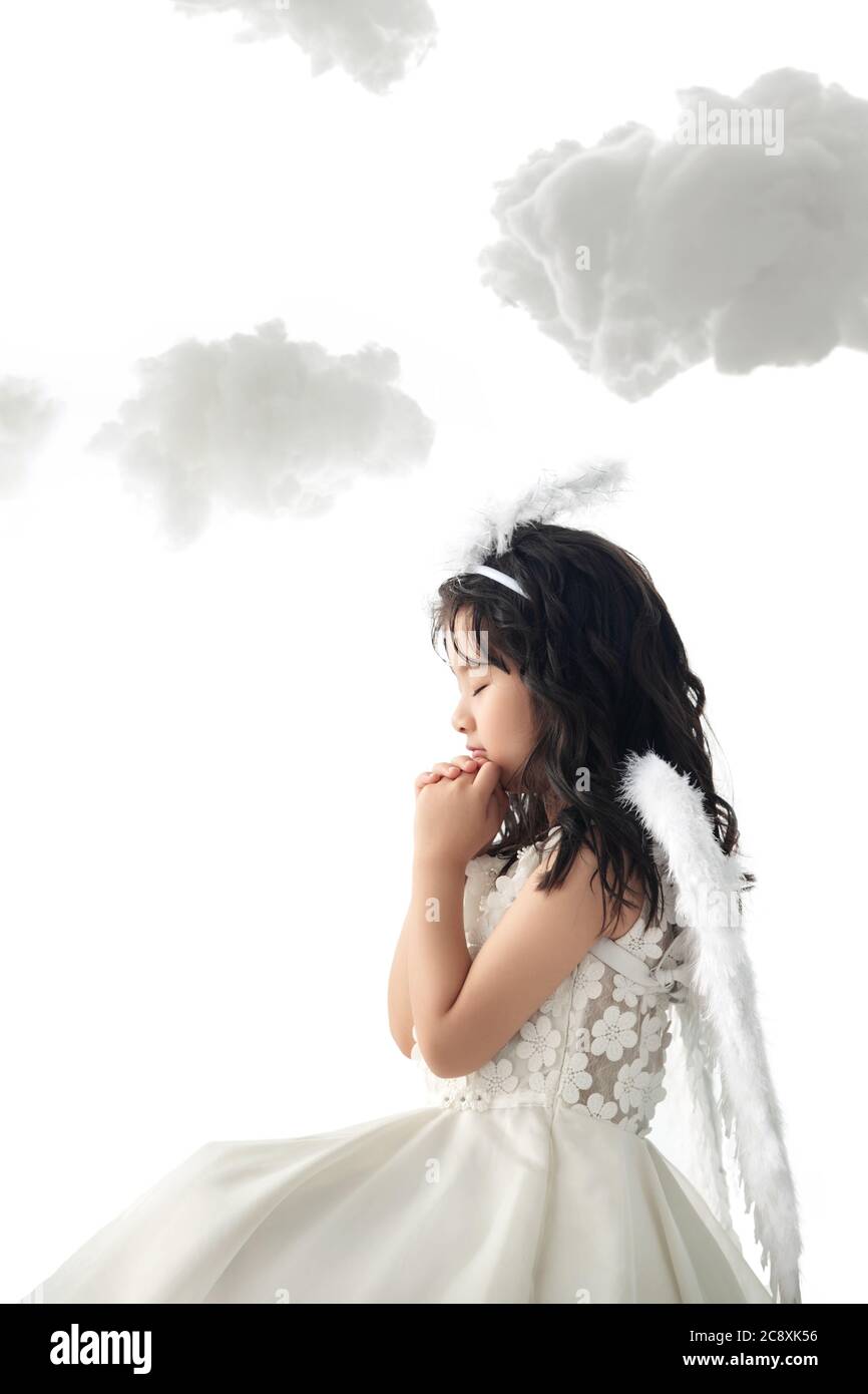 Happy little angel praying Stock Photo - Alamy