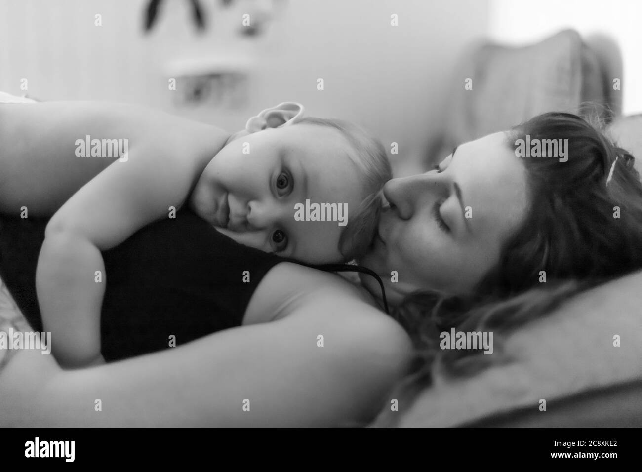 Mother and baby cuddle and snuggle in intimacy. Baby lying with his ...