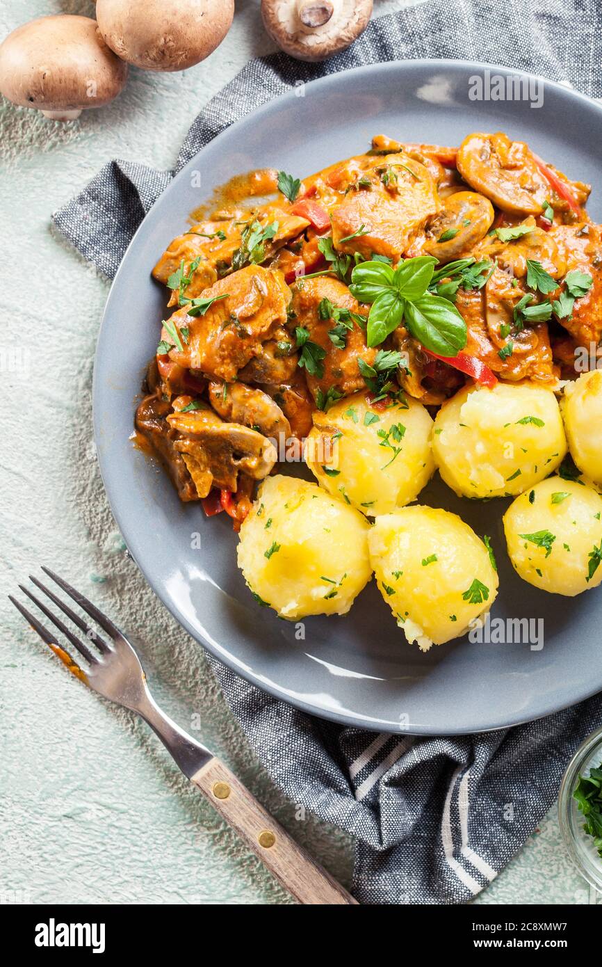 Fresh turkey ragout with mushrooms in creamy sauce with boiled potatoes ...