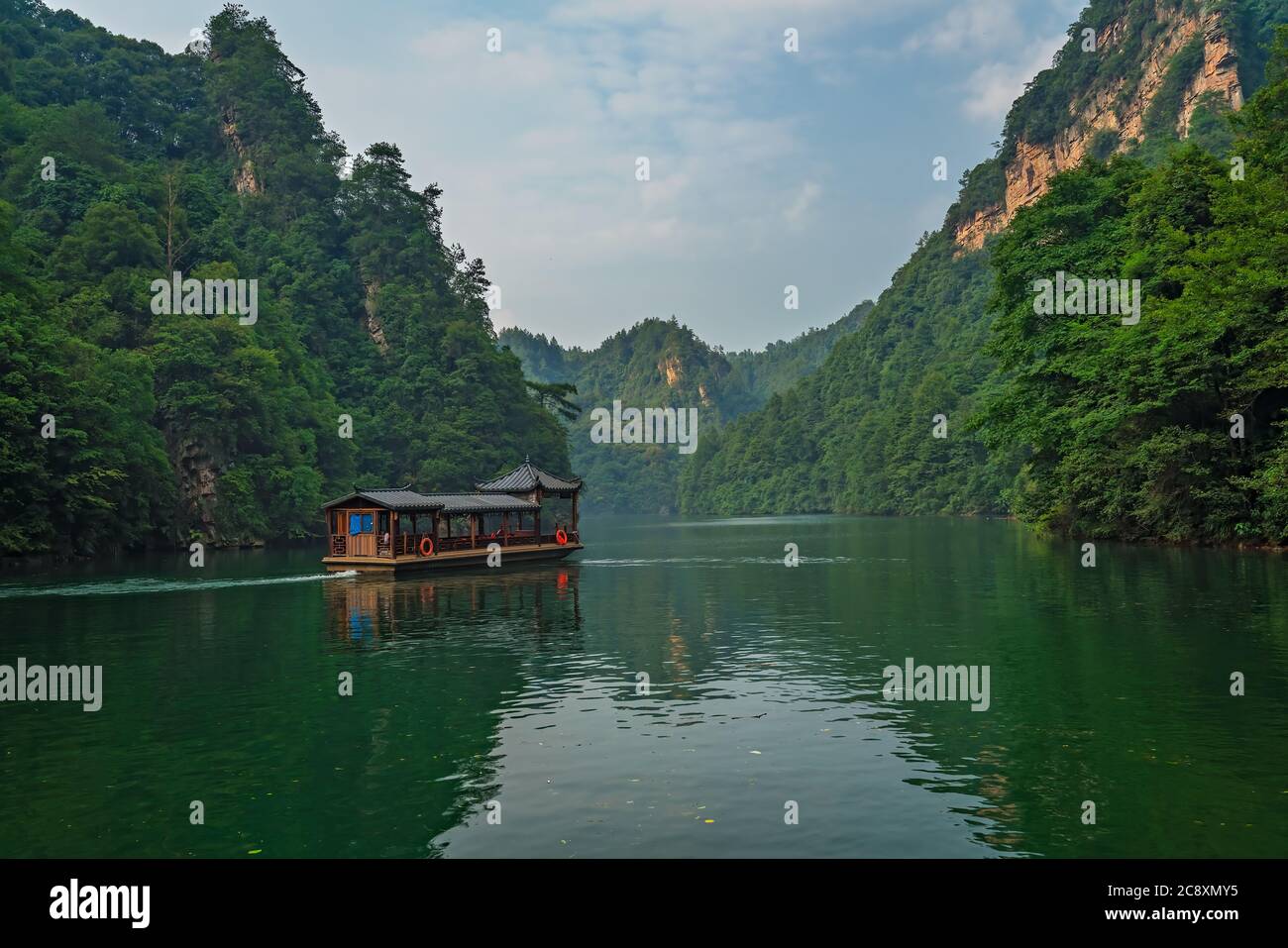 Tourist boat sailing among stunningly beautiful karst landscape ...