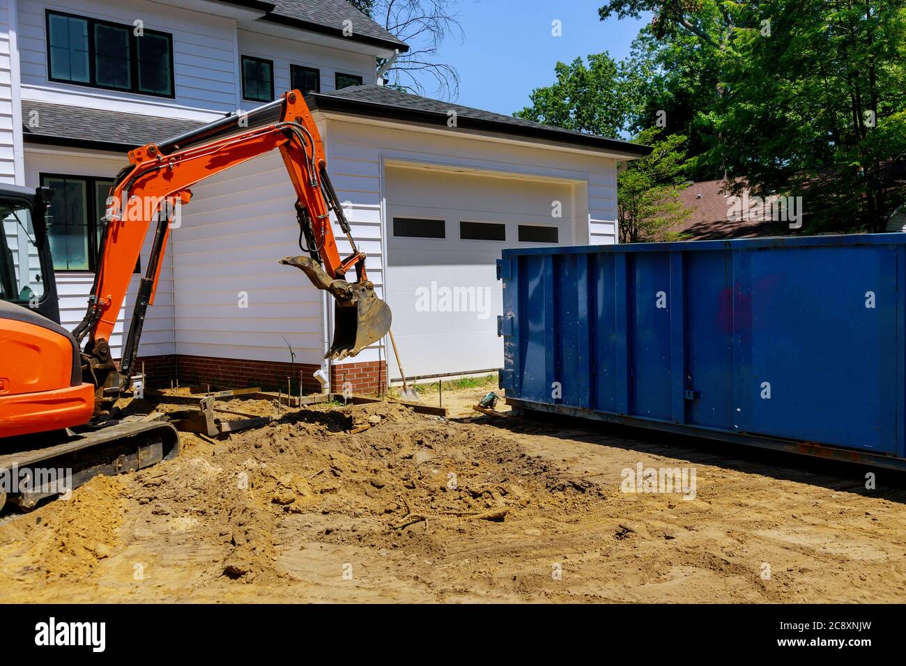 Mini excavator and bobcat on construction site for working in trash ...