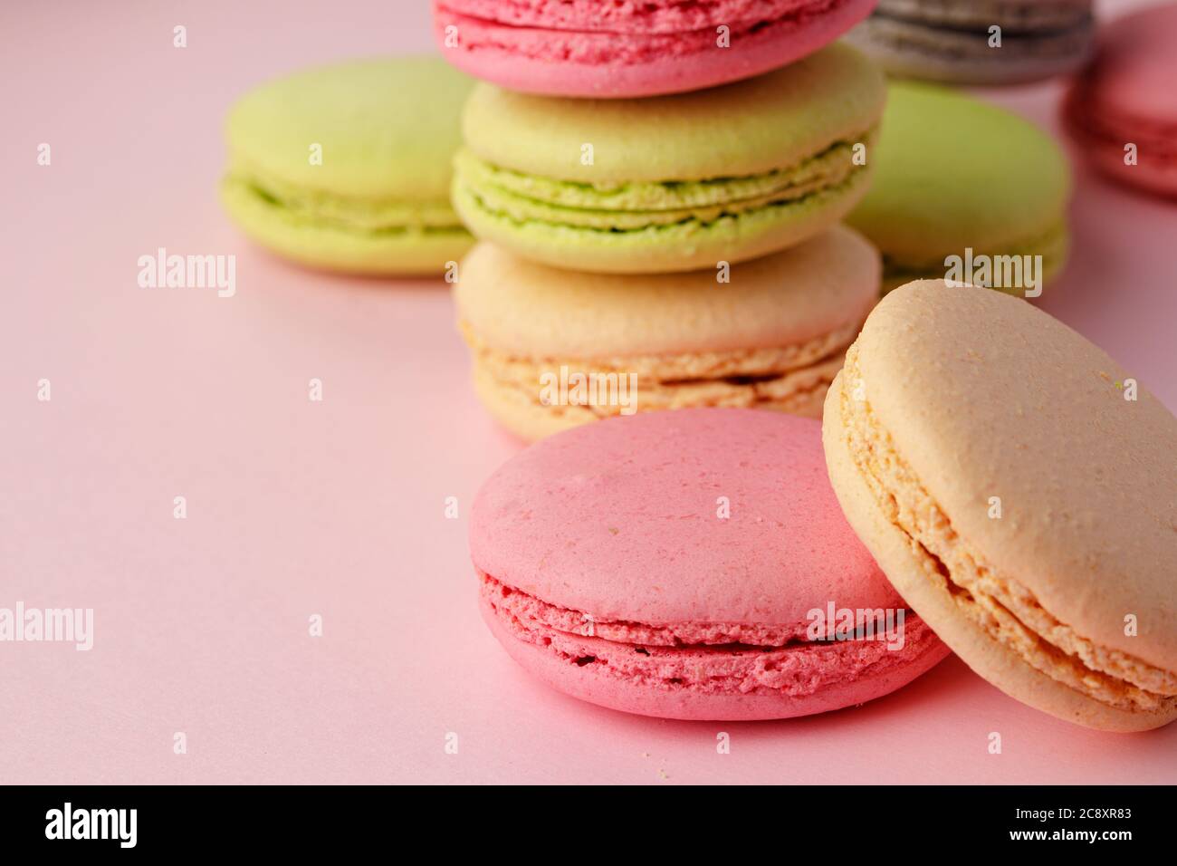 Pile of colorful macaroon cookies on pink background Stock Photo - Alamy