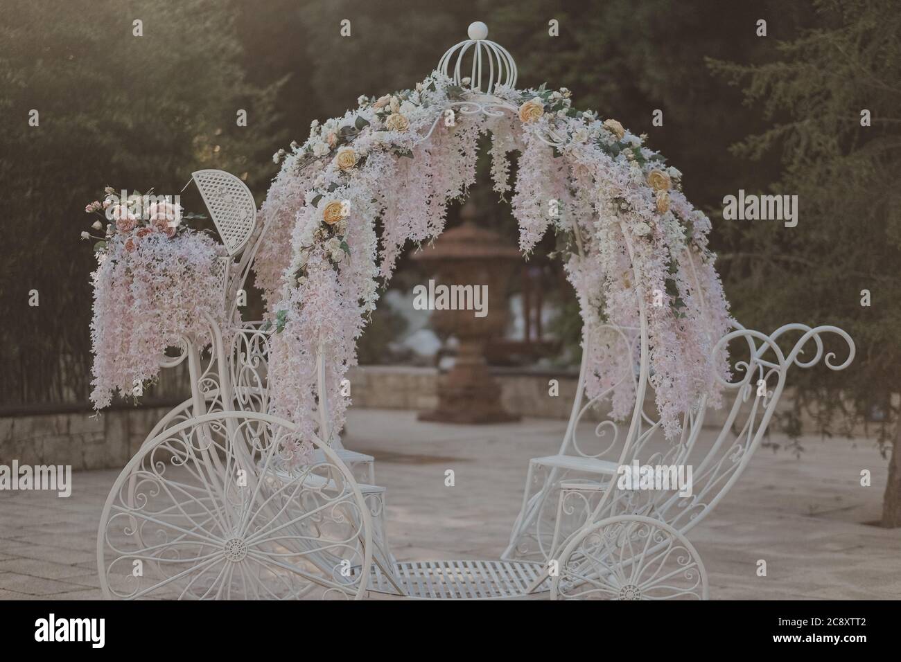 Decorative metal wedding carriage with flowers and a blurred background ...