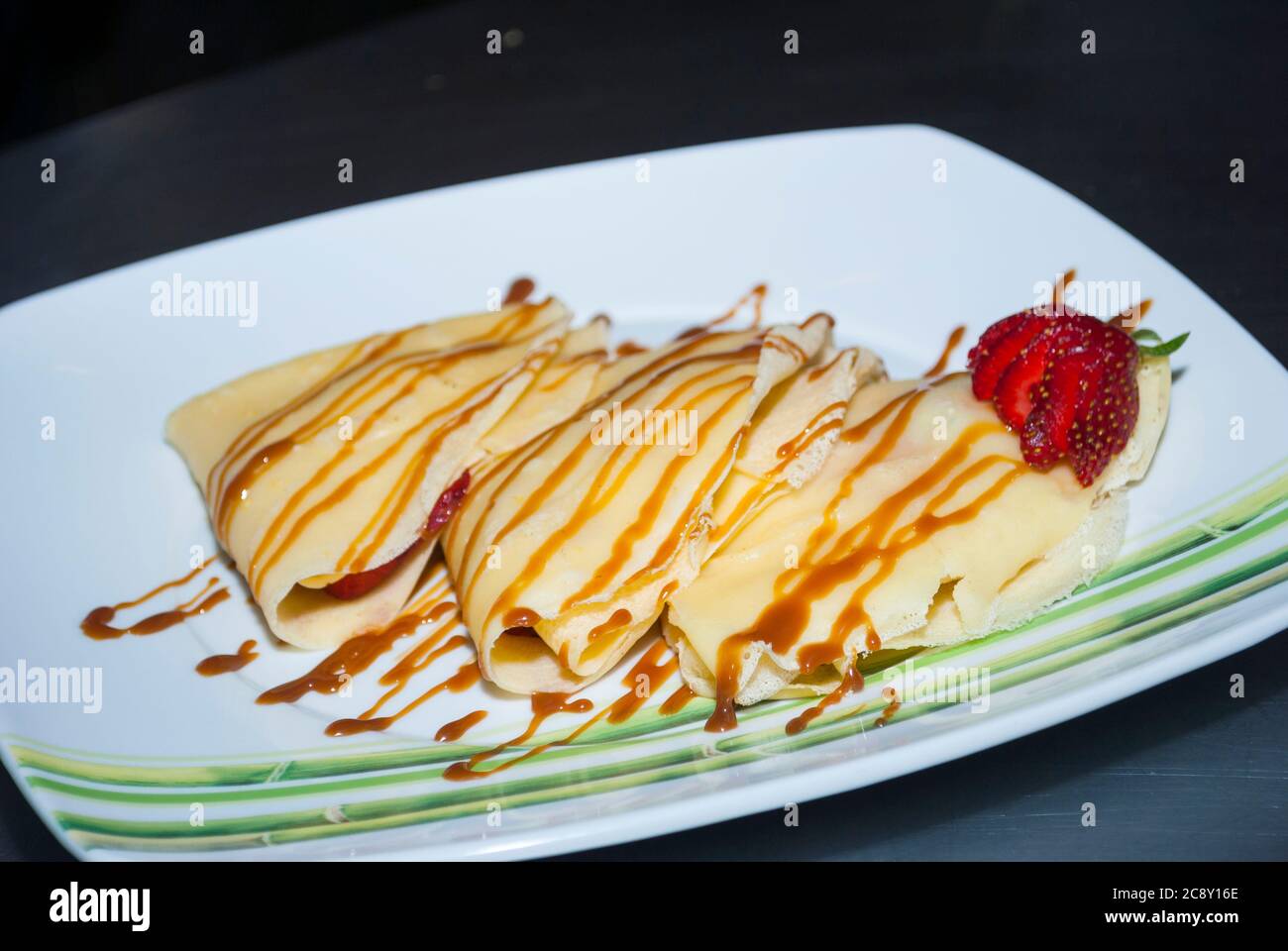 Crepe served on wooden table, outdoors, sweet dessert with strawberry ...