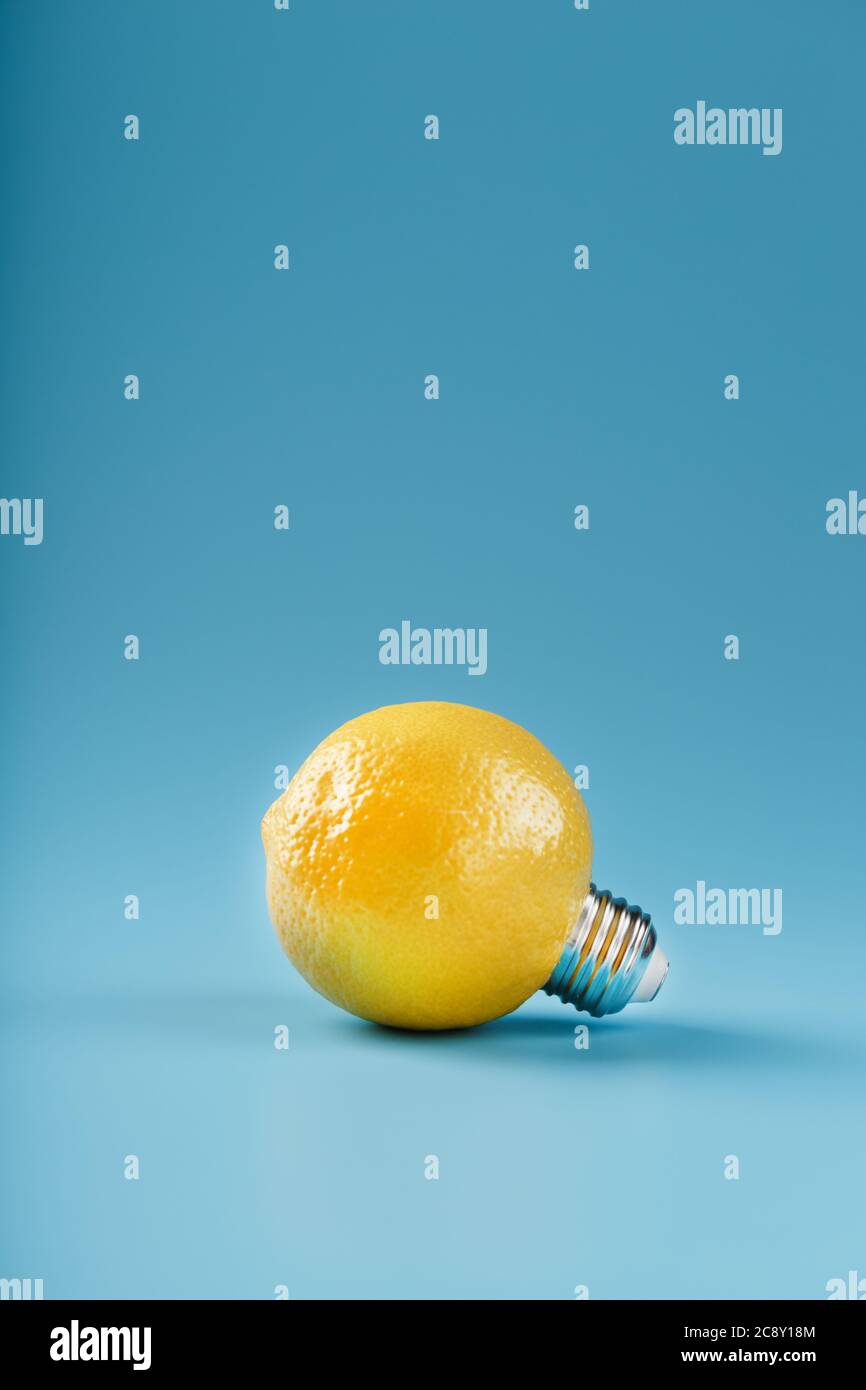 The light bulb is like a lemon on a blue background Stock Photo - Alamy