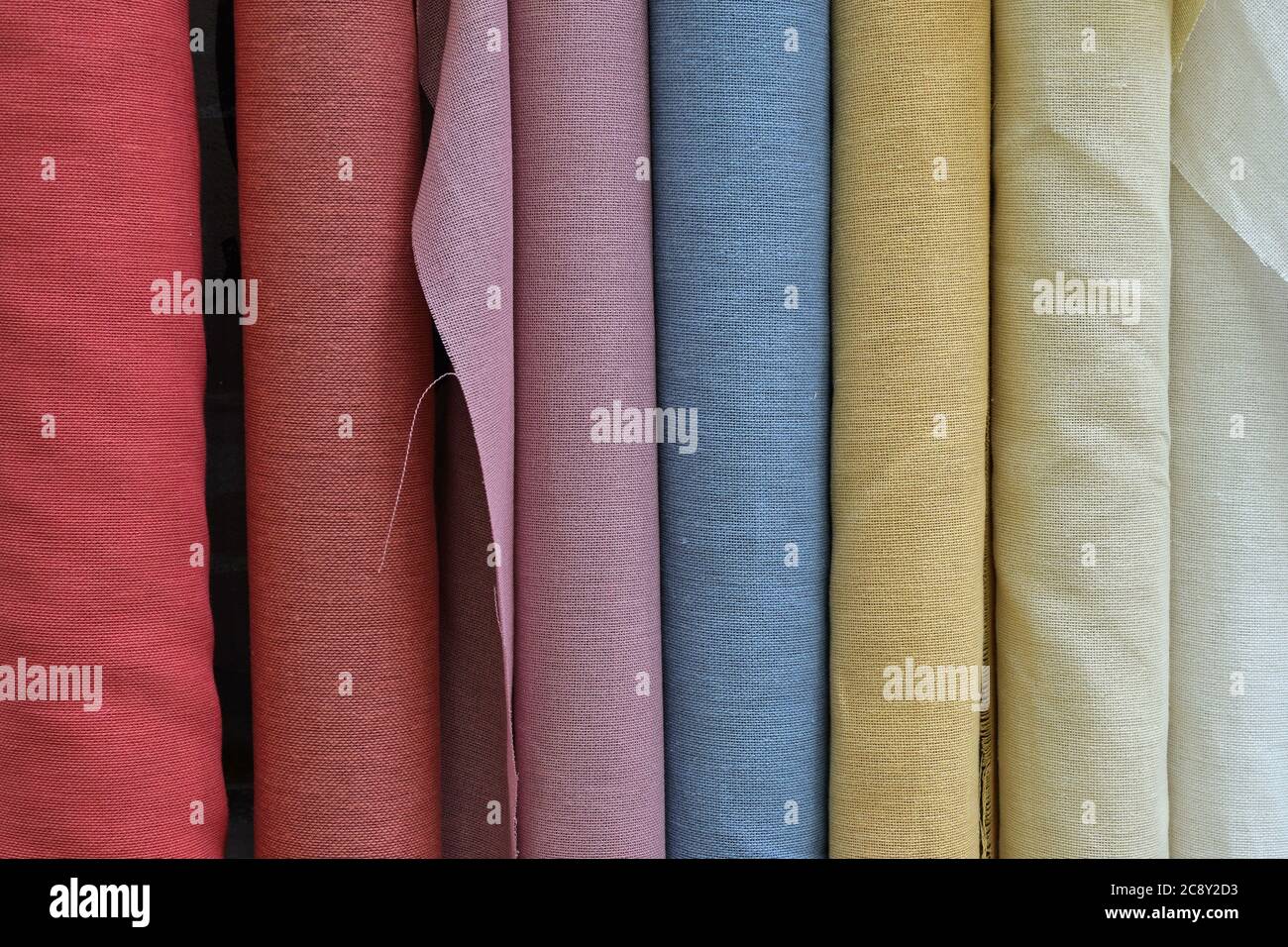 Rolls of plain monochrome textile fabric material in various colors ...