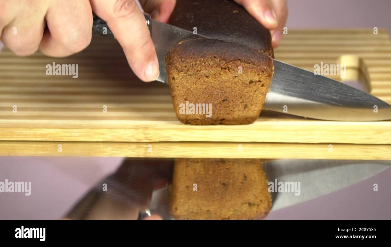 front view of brick of bread. Mans hand take off a front part of bread ...