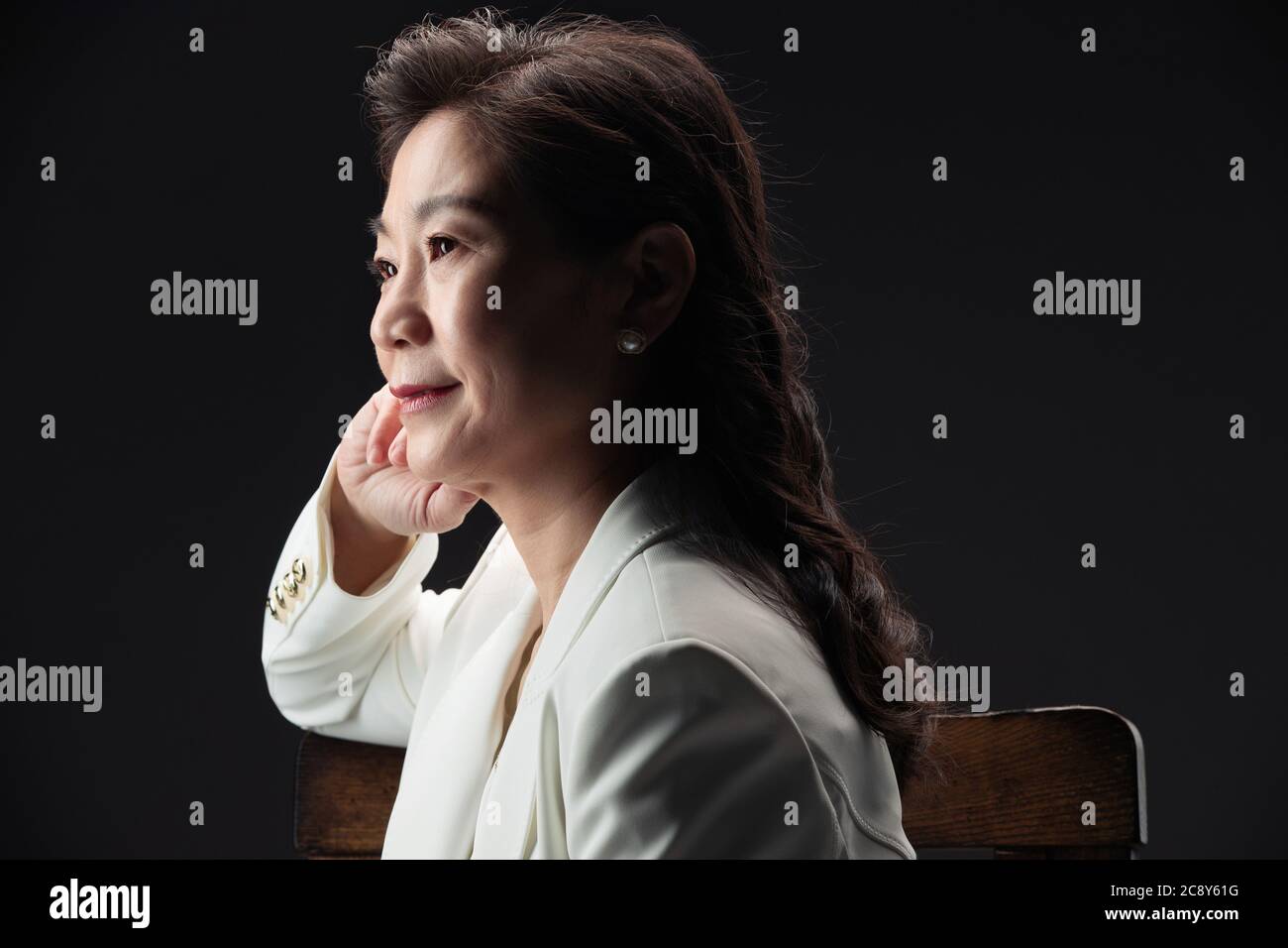 Hands on chin a business woman Stock Photo - Alamy
