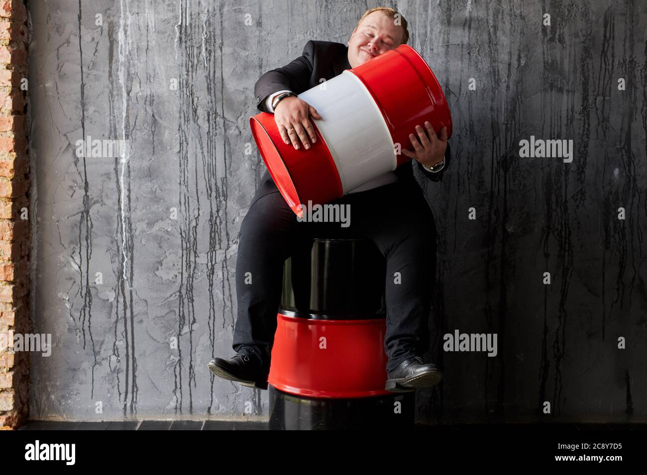 happy young fat oilman hugs barrel, his company holds its brand on ...