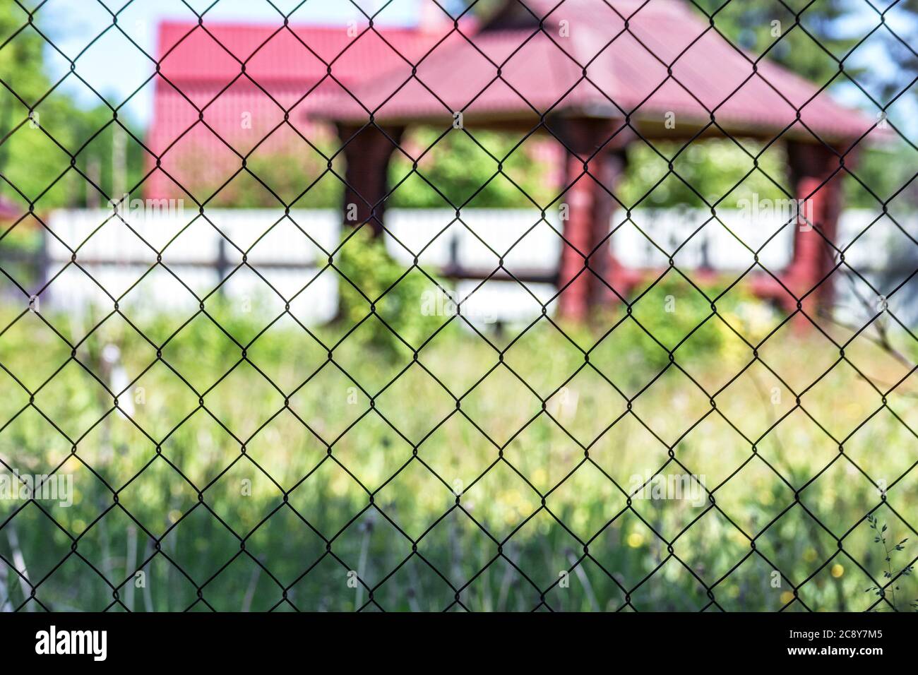 View of the village landscape through an iron grid with rectangular ...