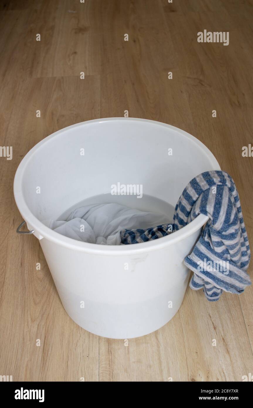 Hand wash. White plastic wash bowl with clothes in it Stock Photo - Alamy