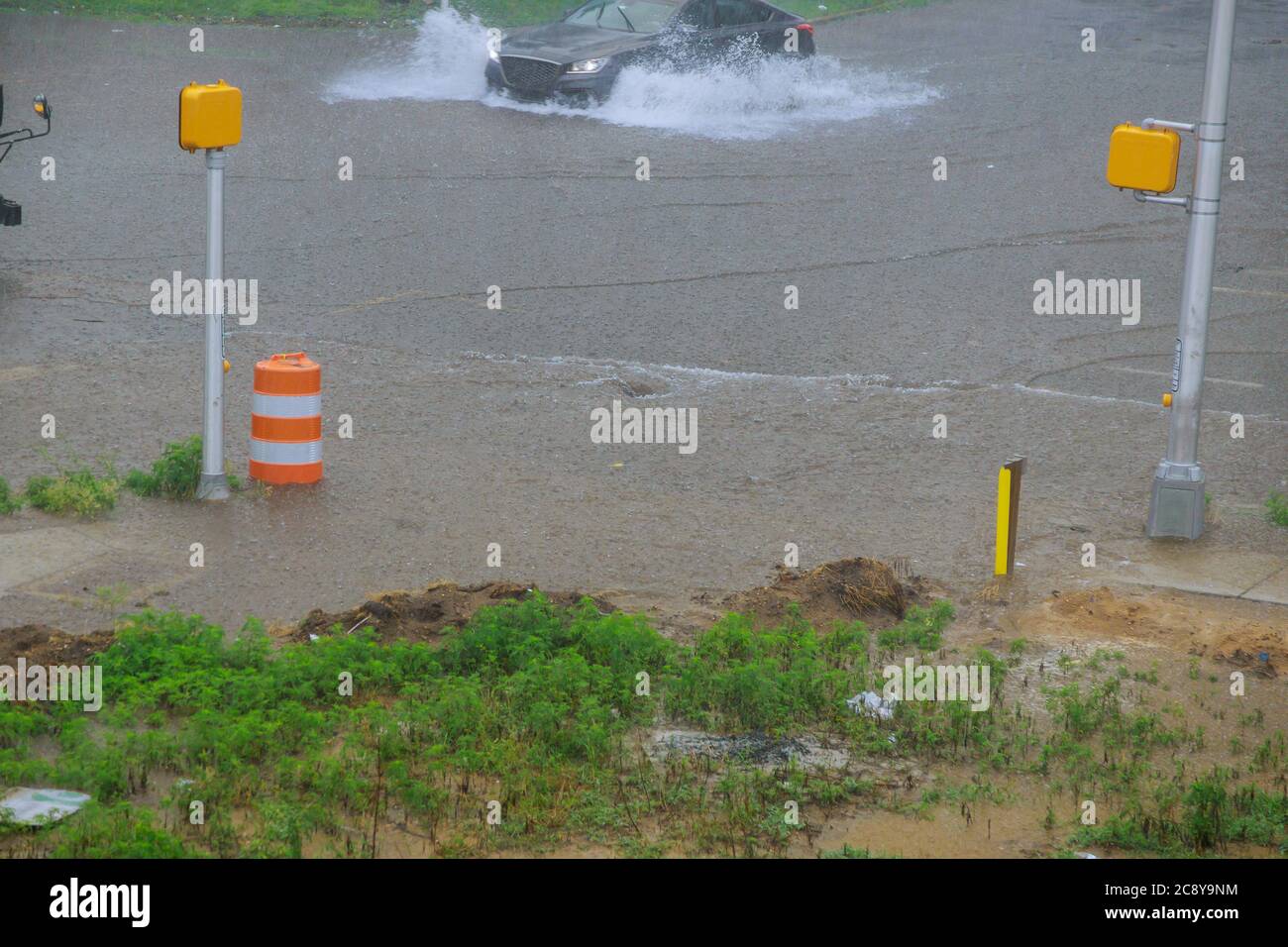 Street flooded heavy rain drops on car is driving through a big puddle ...