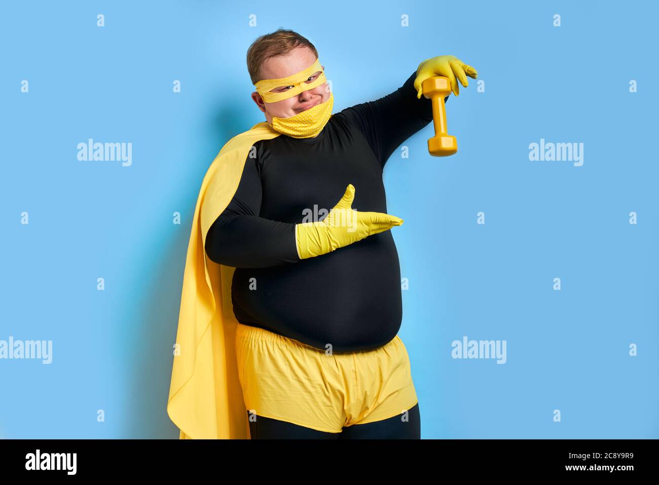 comical superhero guy shows at one dumbbell isolated over blue ...