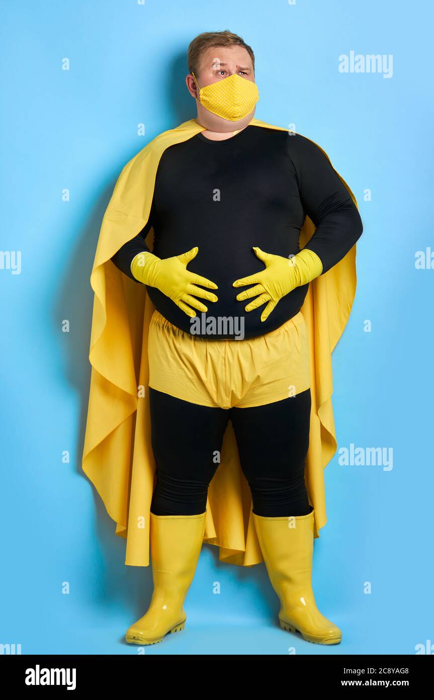 emotional fat caucasian superhero in mask isolated over blue background ...