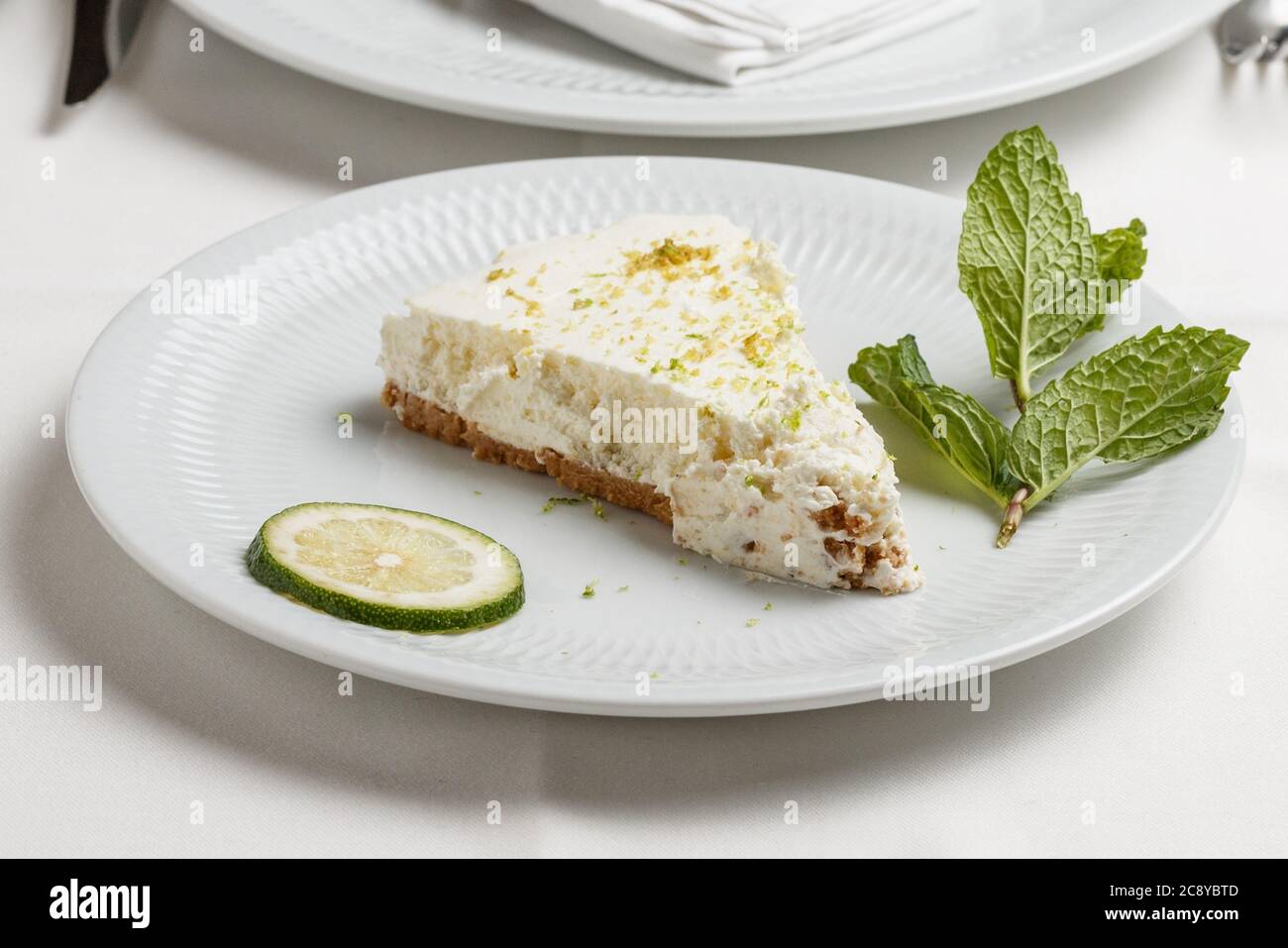 Cheesecake on a white plate with a blurred background Stock Photo - Alamy