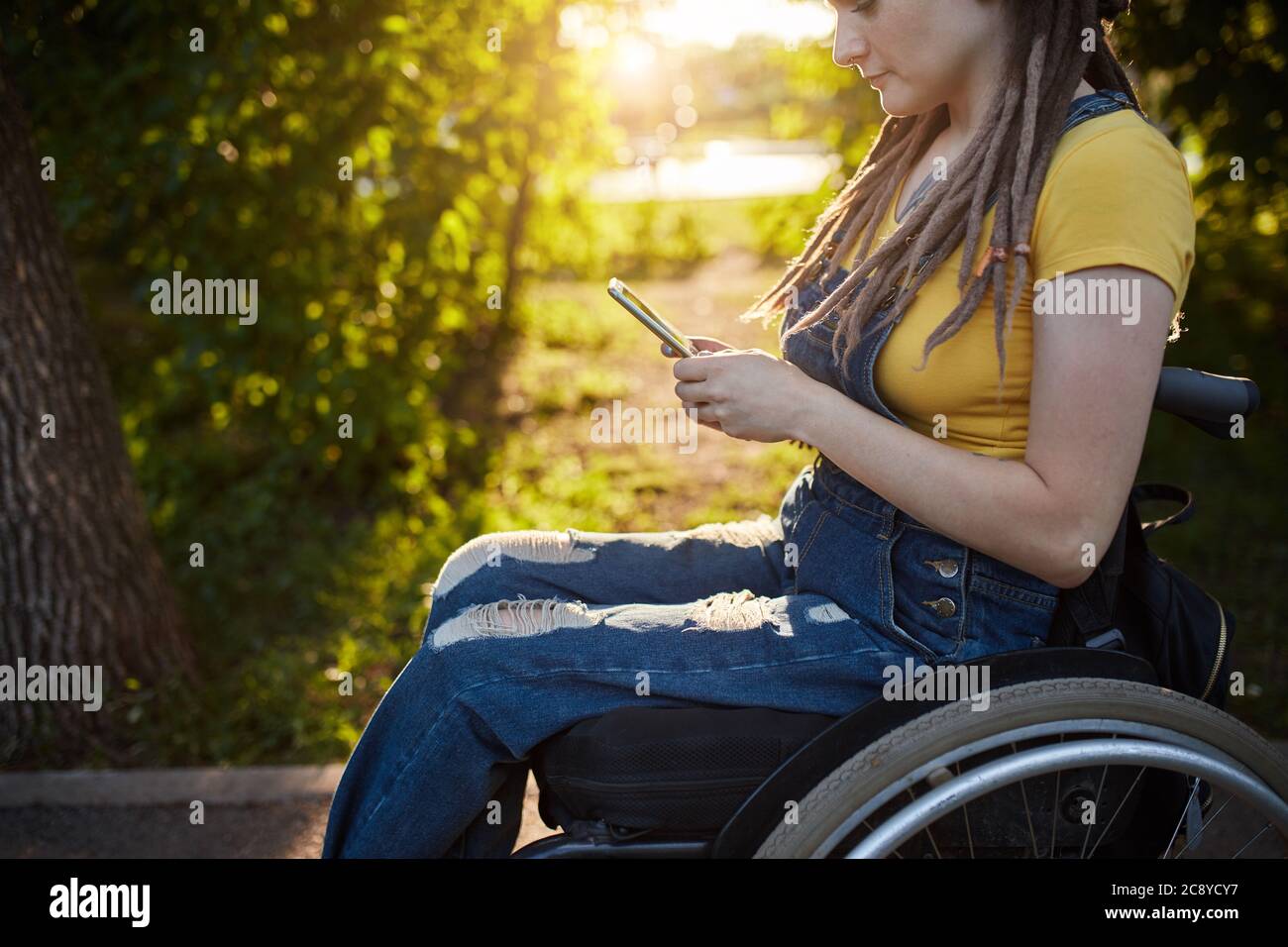 serious girl reading e-book, news, information form the Net in the park ...