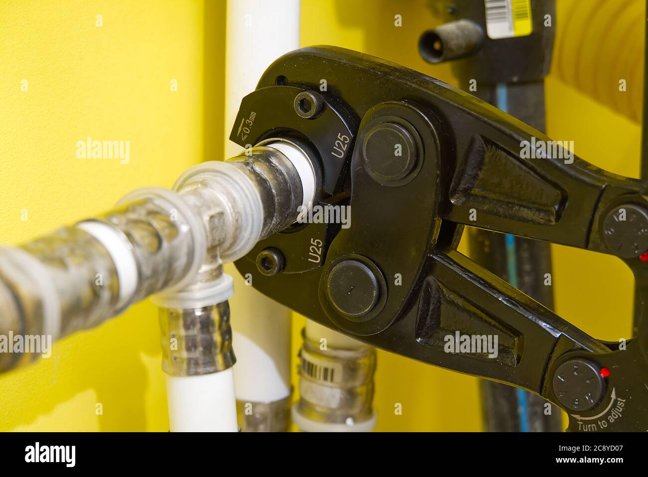 Worker connecting alupex pipes with a tap. Hand press for water pipes ...