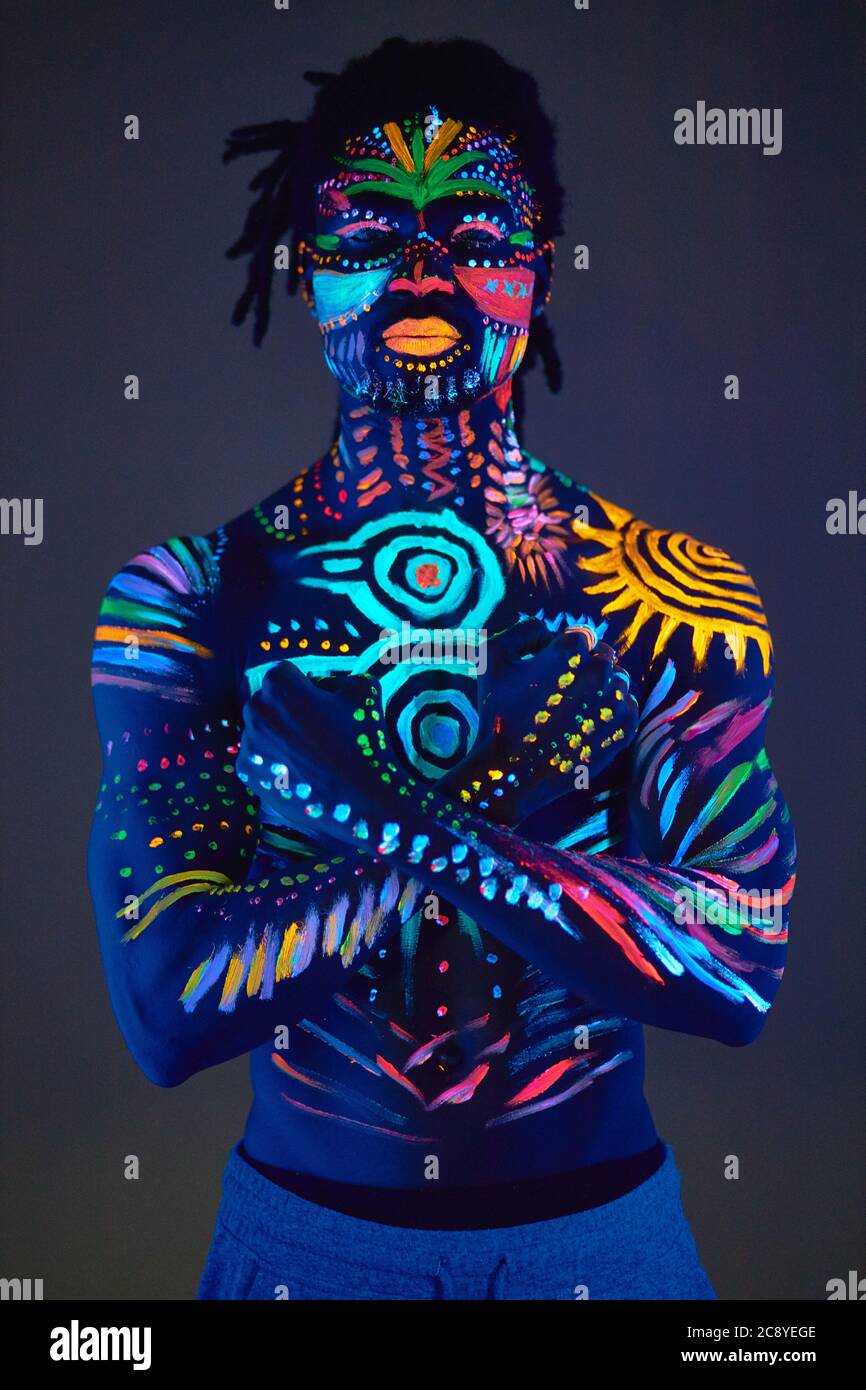 portrait of african man painted in fluorescent paint on face and ...